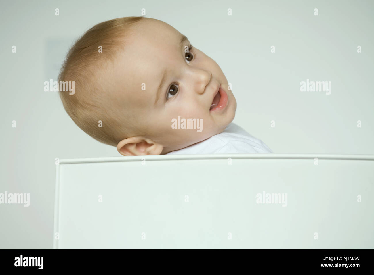 Baby sitting in chair, leaning head back Stock Photo - Alamy