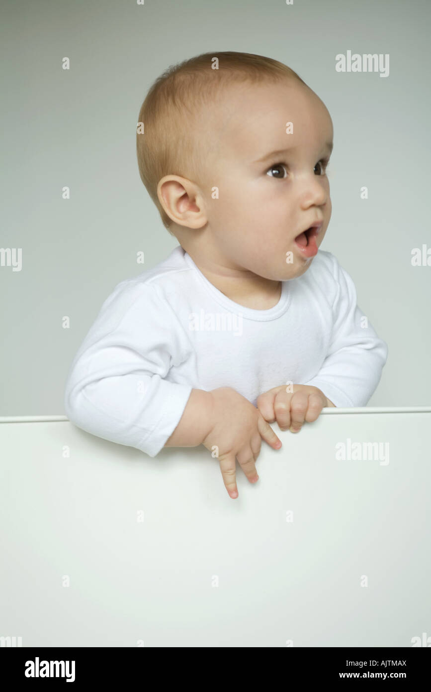 Baby looking away, raising eyebrows, mouth wide open Stock Photo - Alamy