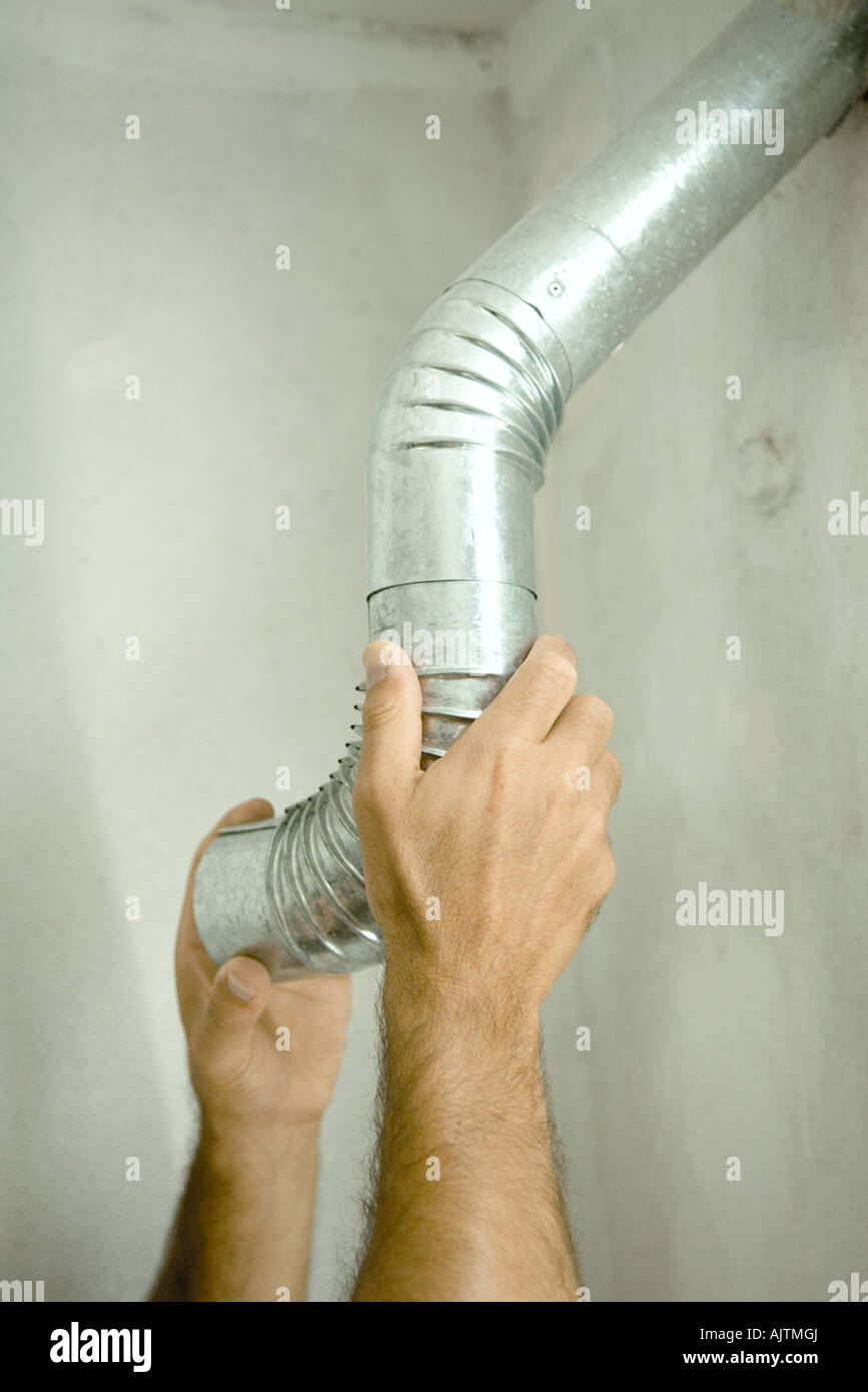 Man adjusting air duct, close-up of hands Stock Photo - Alamy