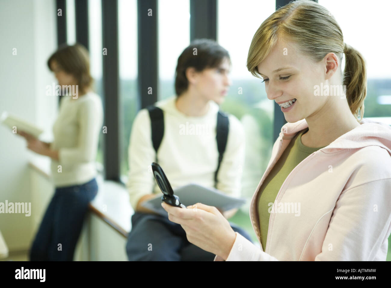 Female college student looking at cell phone, smiling Stock Photo - Alamy