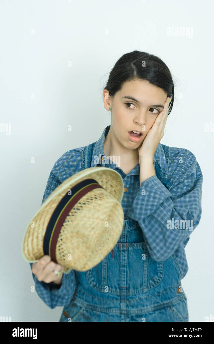 Teenage girl holding cheek, open mouth, looking away Stock Photo - Alamy