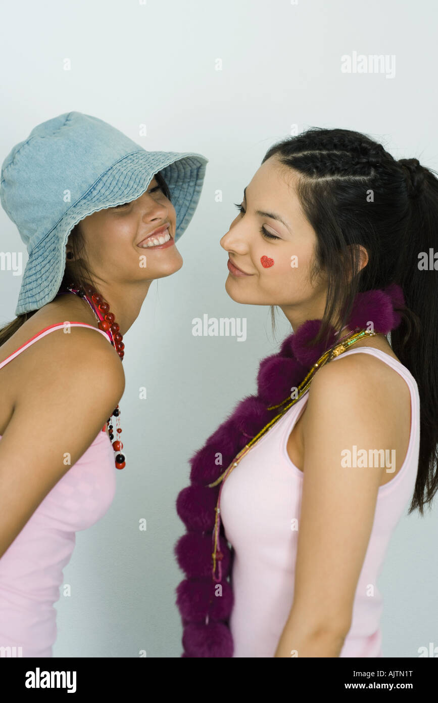 Two young friends standing face to face, smiling at each other Stock ...