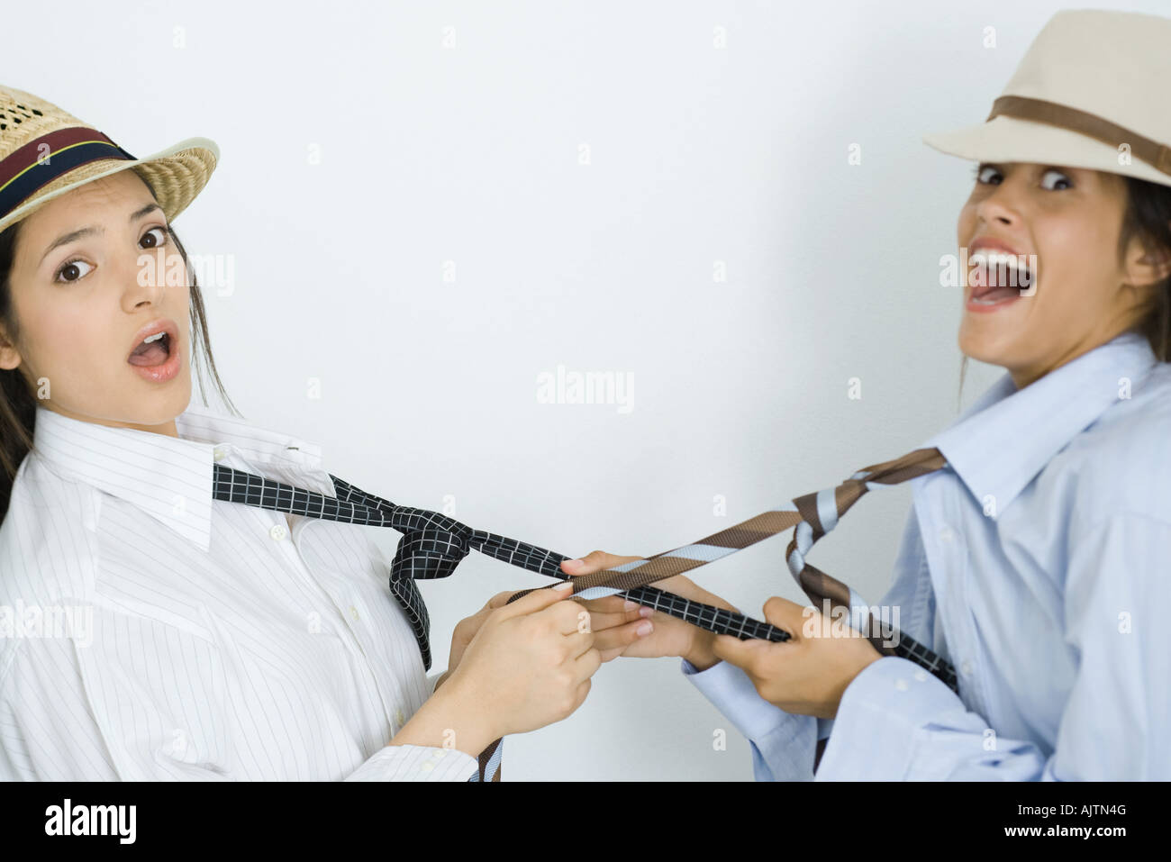 Young woman pulling friends hat hi-res stock photography and images - Alamy