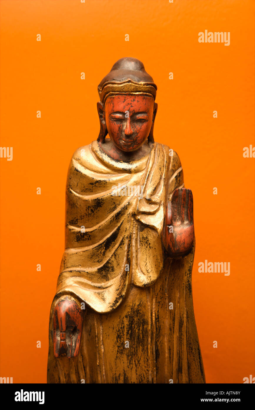 Wooden Buddha statue gesturing with one hand up and one hand down ...
