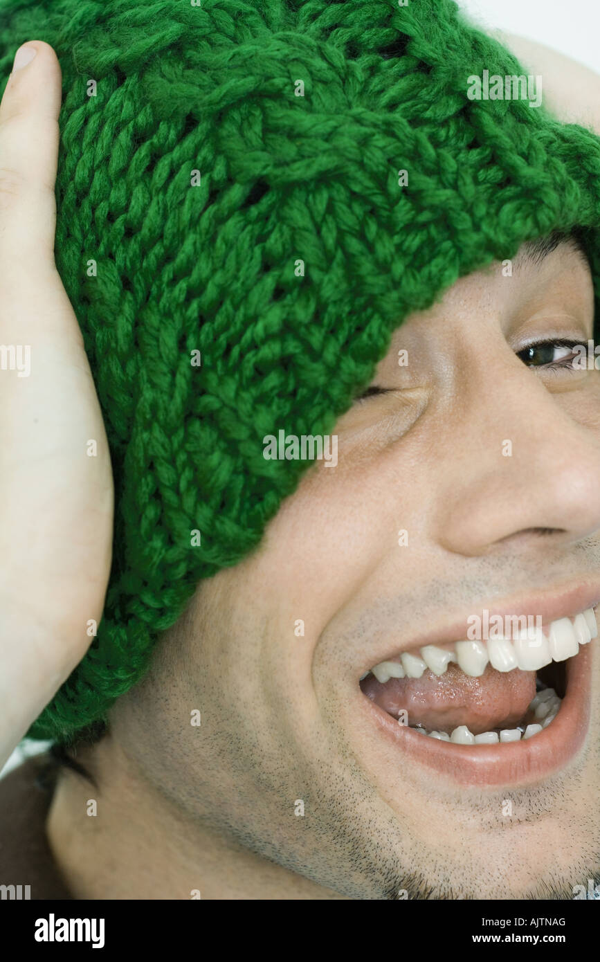 Young man wearing knit hat, one eye covered, laughing at camera Stock ...