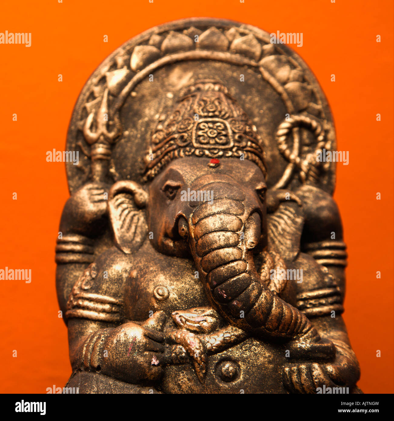 Statue of Hindu elephant Ganesha against orange wall Stock Photo - Alamy