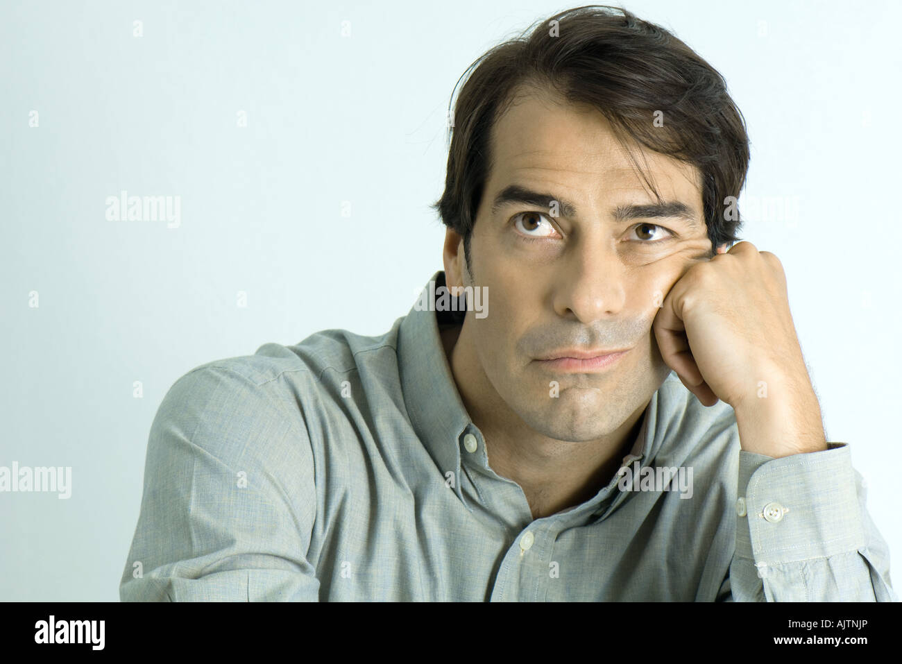 Man leaning head on hand, looking up, portrait Stock Photo - Alamy