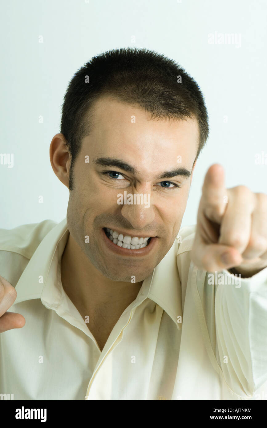 Man making face and pointing at camera, portrait Stock Photo - Alamy