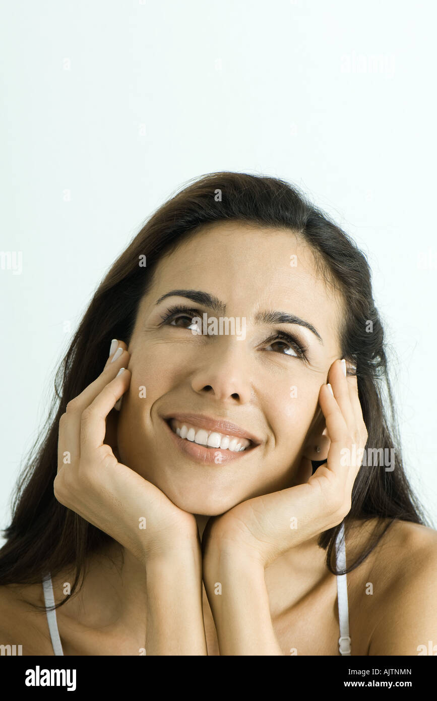 Woman holding face between hands, smiling, looking up, portrait Stock ...