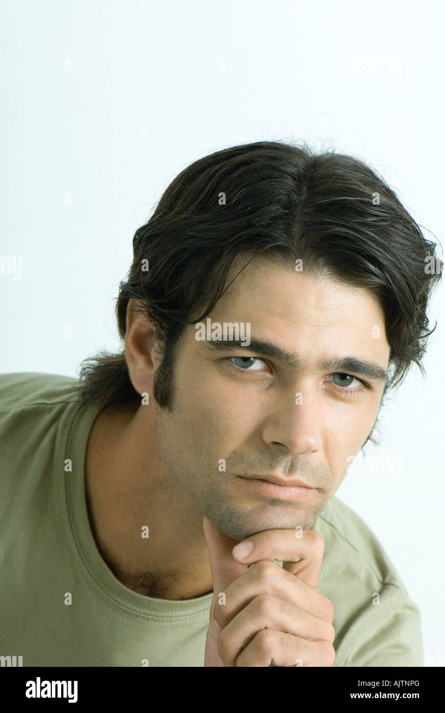 Man holding chin, looking at camera, portrait Stock Photo - Alamy
