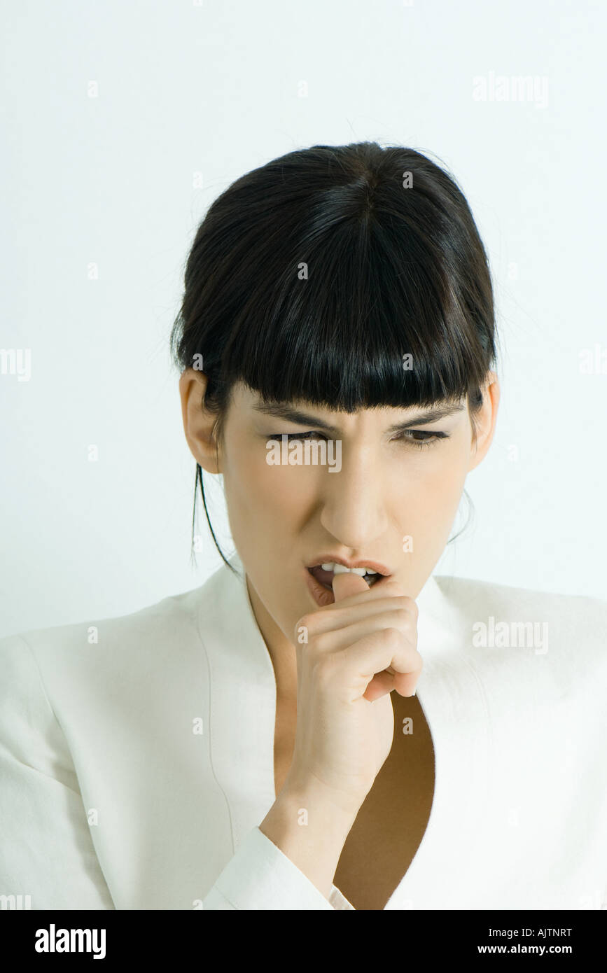 Well-dressed young businesswoman biting thumb, portrait Stock Photo - Alamy