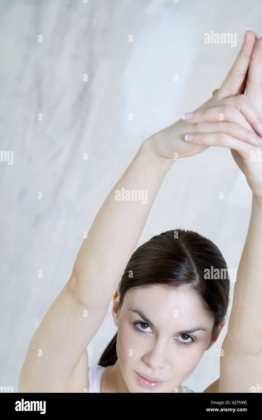 Young woman looking at camera, arms raised, high angle view Stock Photo ...