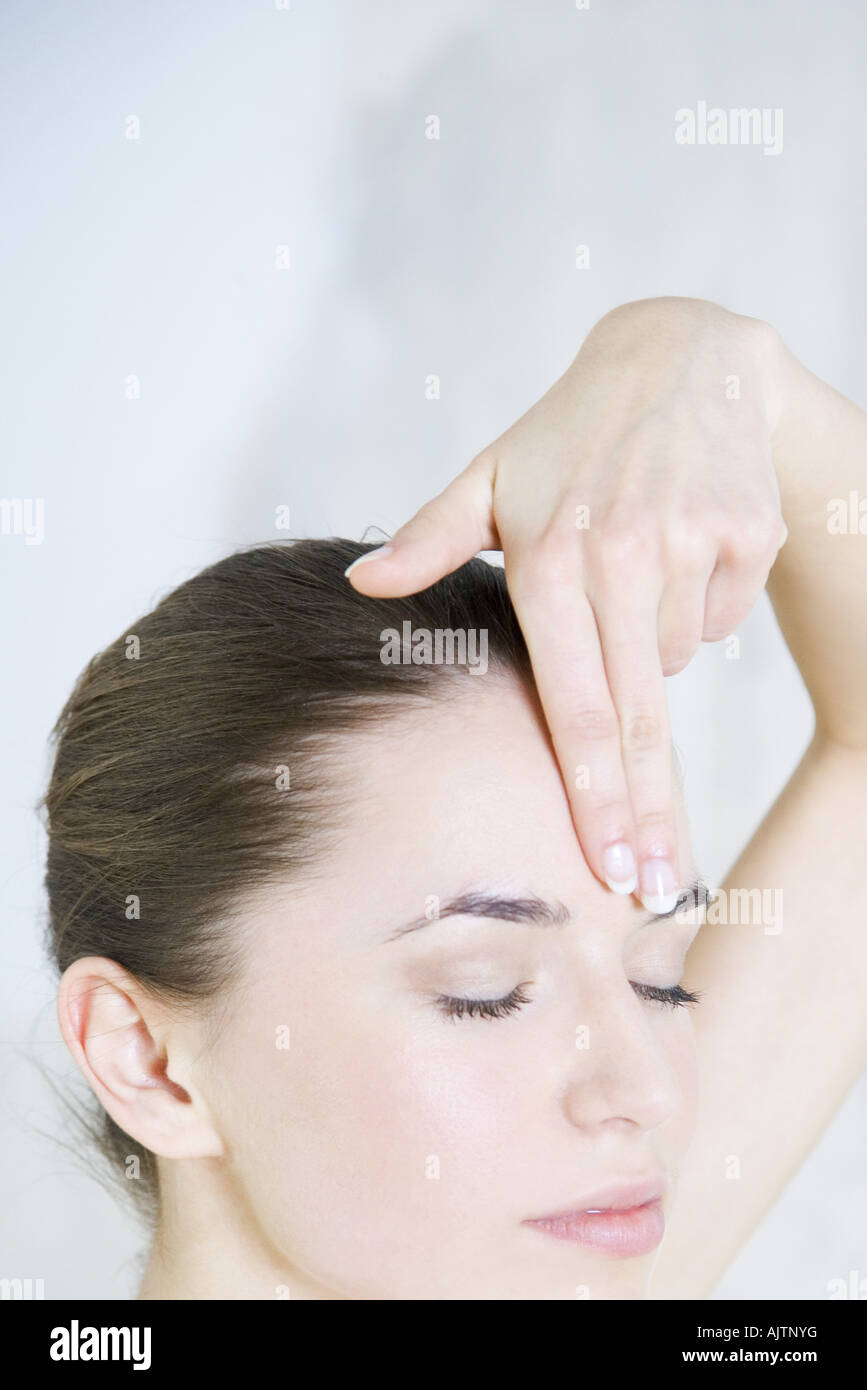 Young woman touching forehead, eyes closed, cropped view Stock Photo ...
