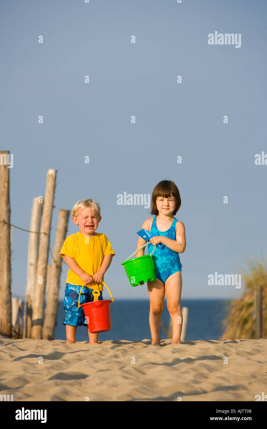 Sister and crying brother at the beach Stock Photo - Alamy