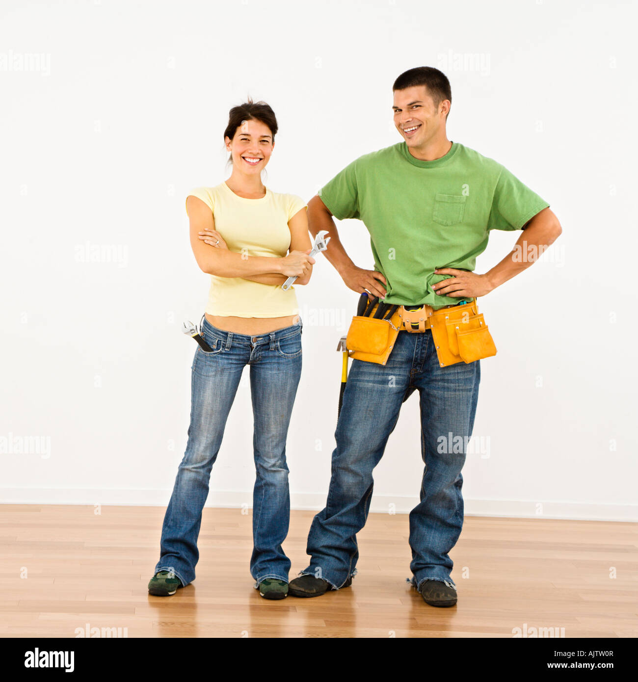 Couple with tools standing and smiling in home Stock Photo - Alamy