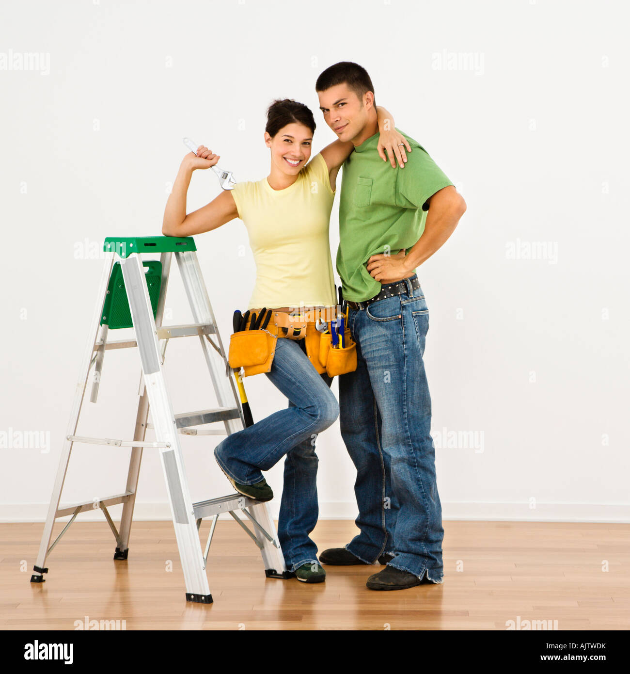 Couple with tools and ladder standing in home smiling Stock Photo - Alamy