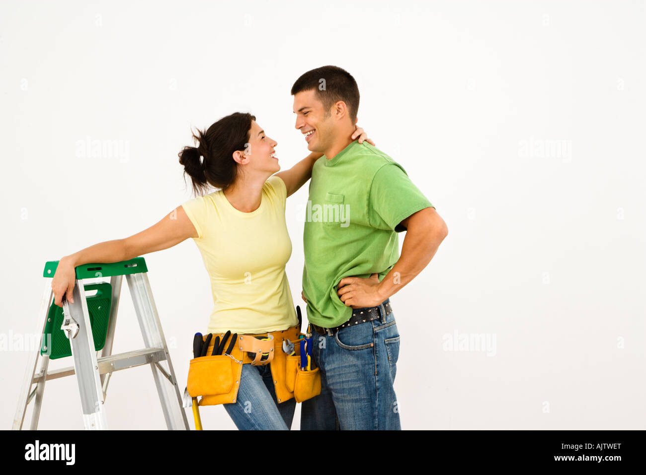 Couple with tools and ladder standing in home smiling Stock Photo - Alamy