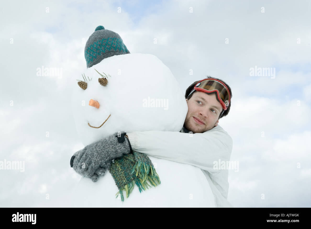 Young man hugging snowman Stock Photo - Alamy