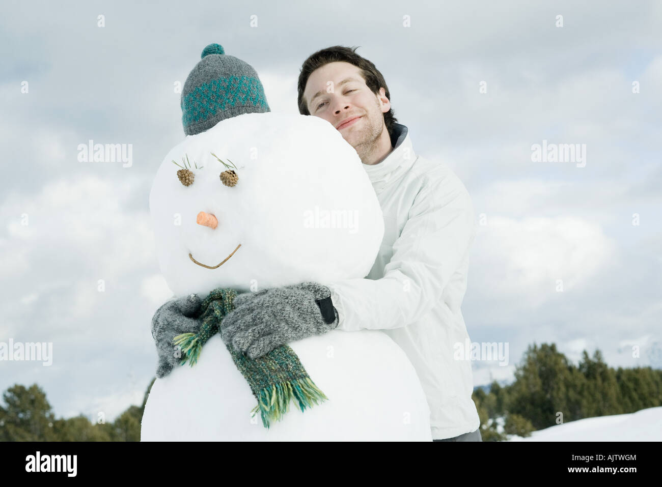 Young man hugging snowman Stock Photo - Alamy