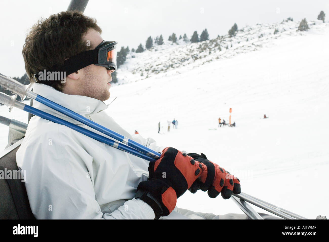 Young man taking ski lift Stock Photo - Alamy