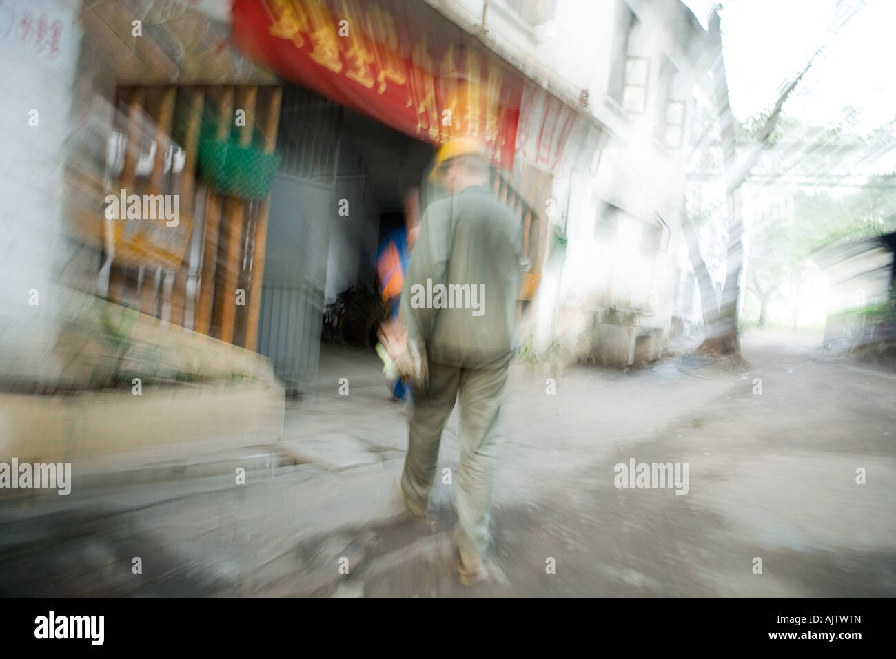 Construction worker walking away, blurred motion Stock Photo - Alamy