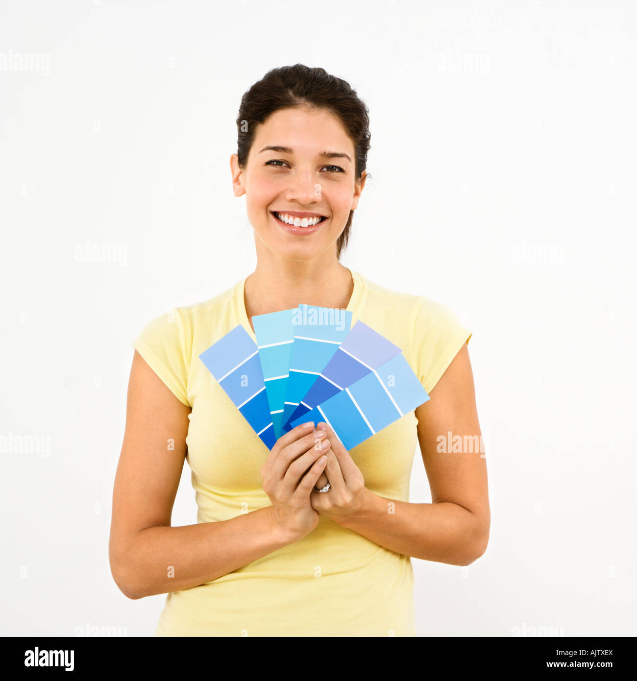 Pretty woman smiling holding out paint sample cards Stock Photo - Alamy