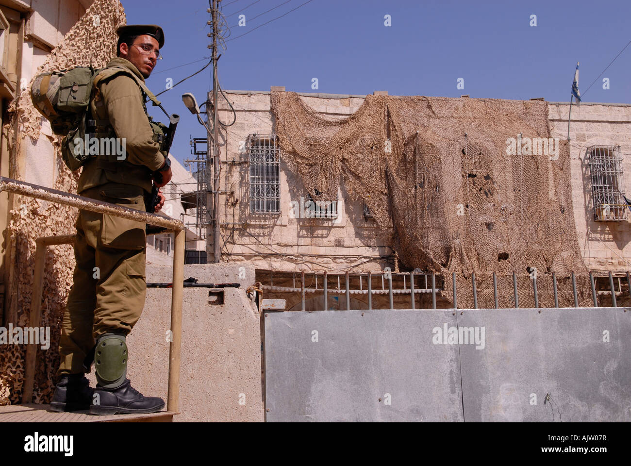 Israeli soldier stands guard in a barrier separating Palestinian Kasbah ...