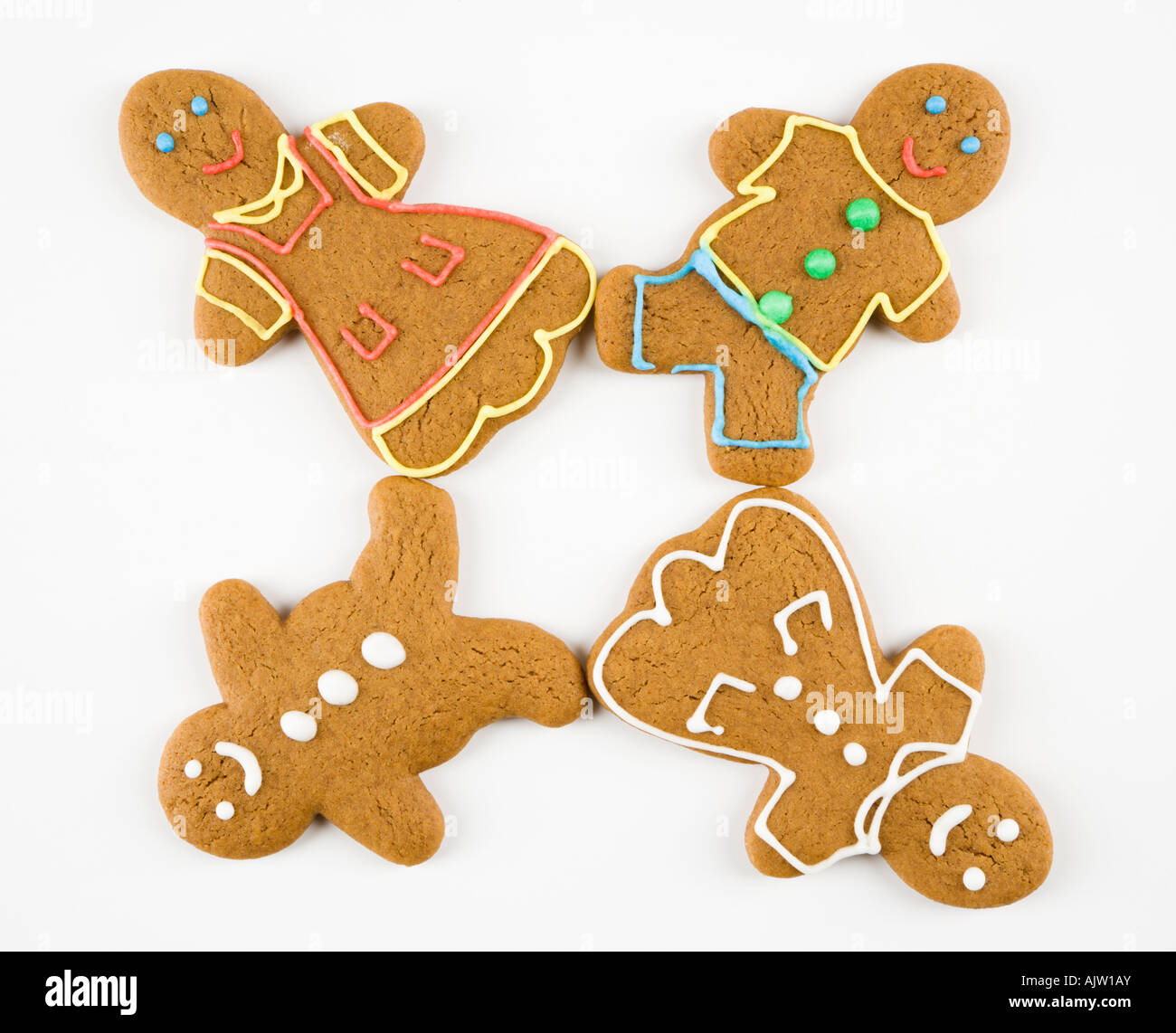 Four male and female gingerbread cookies arranged with feet touching ...