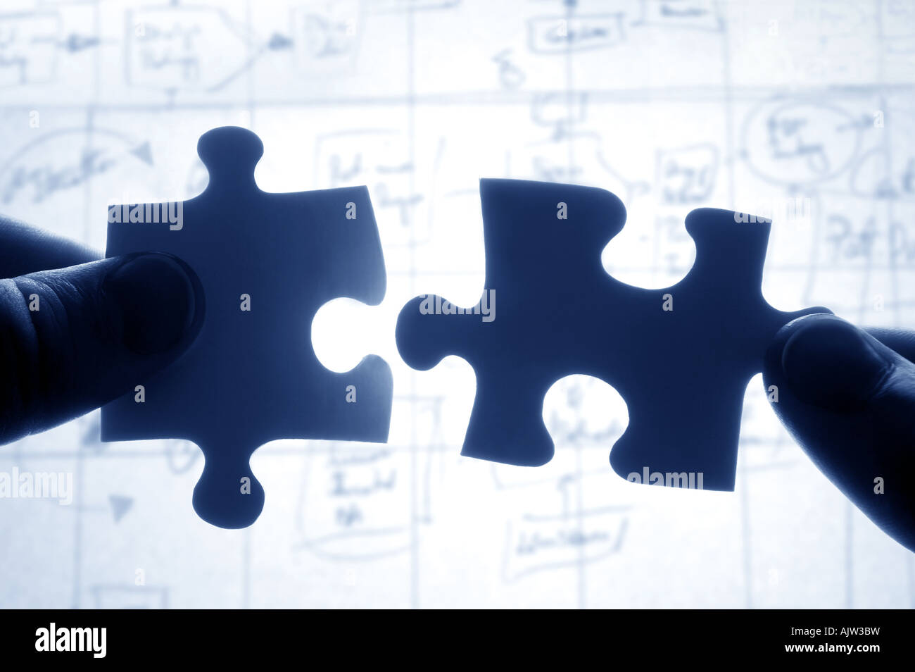 Hands trying to fit two puzzle pieces together Stock Photo - Alamy