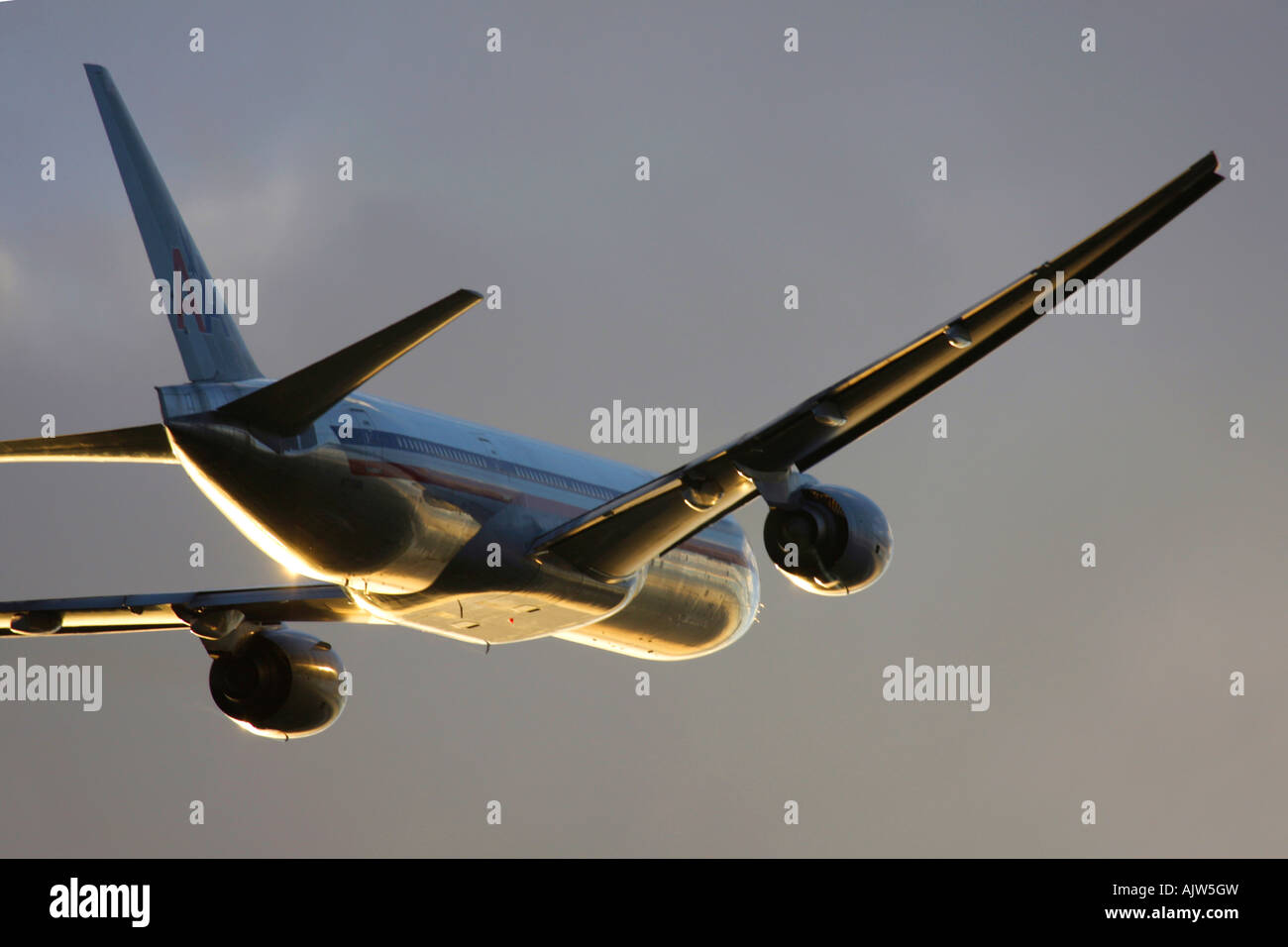 American Airlines Boeing 777 just after take off in reflecting sunset ...