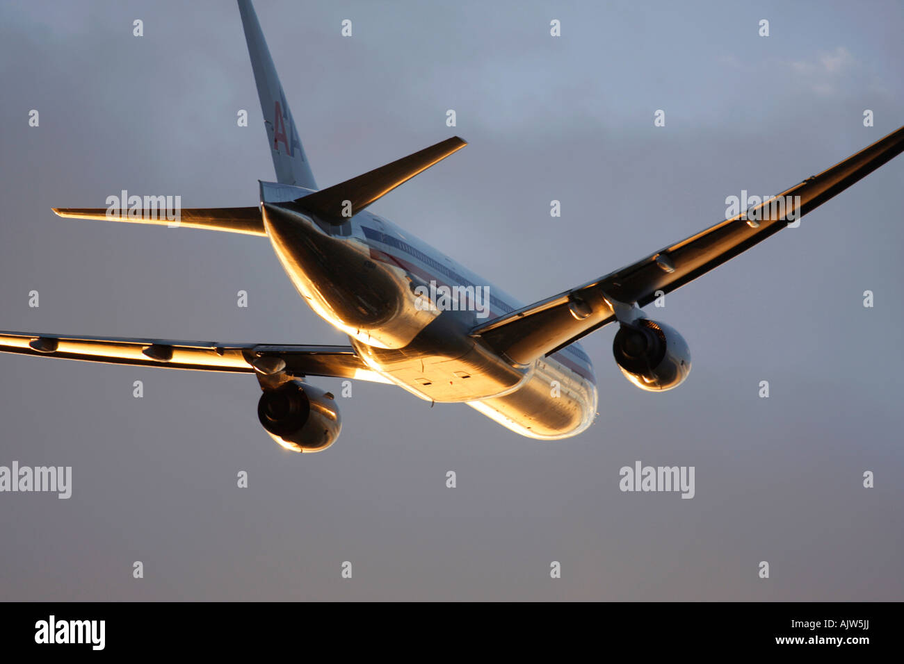 American Airlines Boeing 777 just after take off in reflecting sunset ...