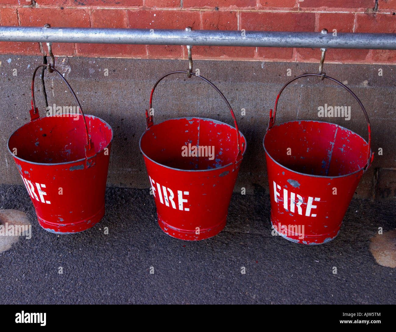 Three fire buckets hanging on a pole Stock Photo - Alamy
