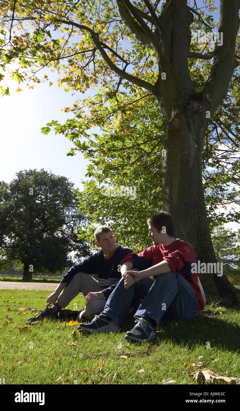 Two men sitting under tree hi-res stock photography and images - Alamy