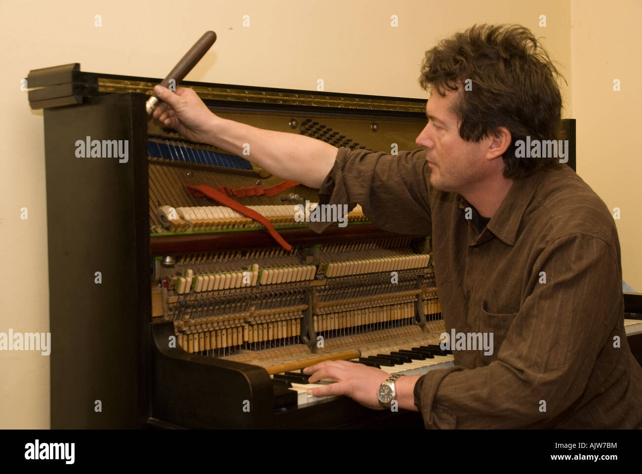 Piano tuner at work tuning an old German upright piano Stock Photo - Alamy