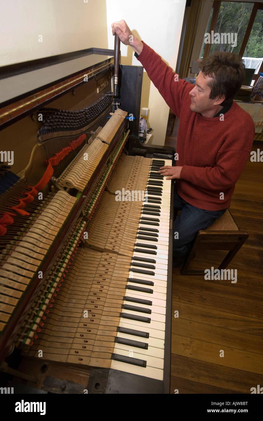 Piano tuner at work tuning an old German upright piano Stock Photo - Alamy