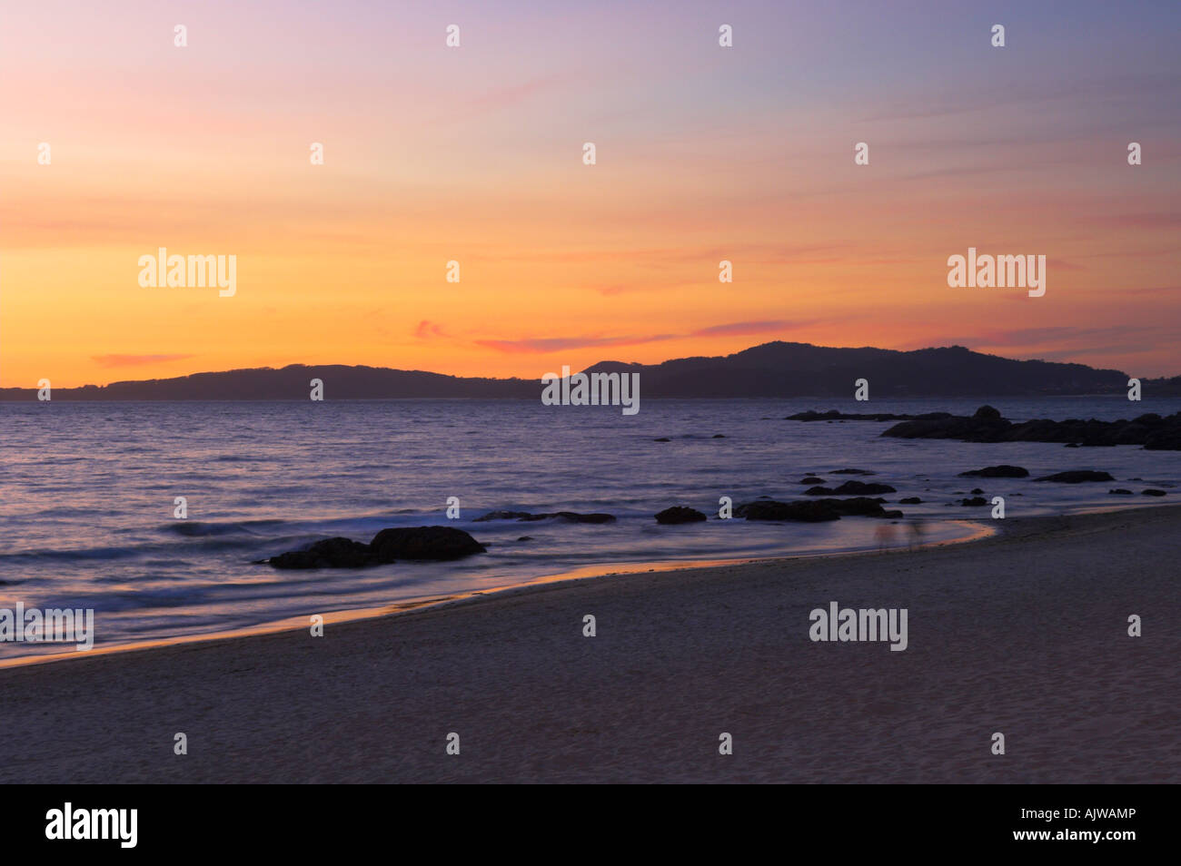 Sunset over water Playa de Samil beach Peninsula de Morrazo in ...