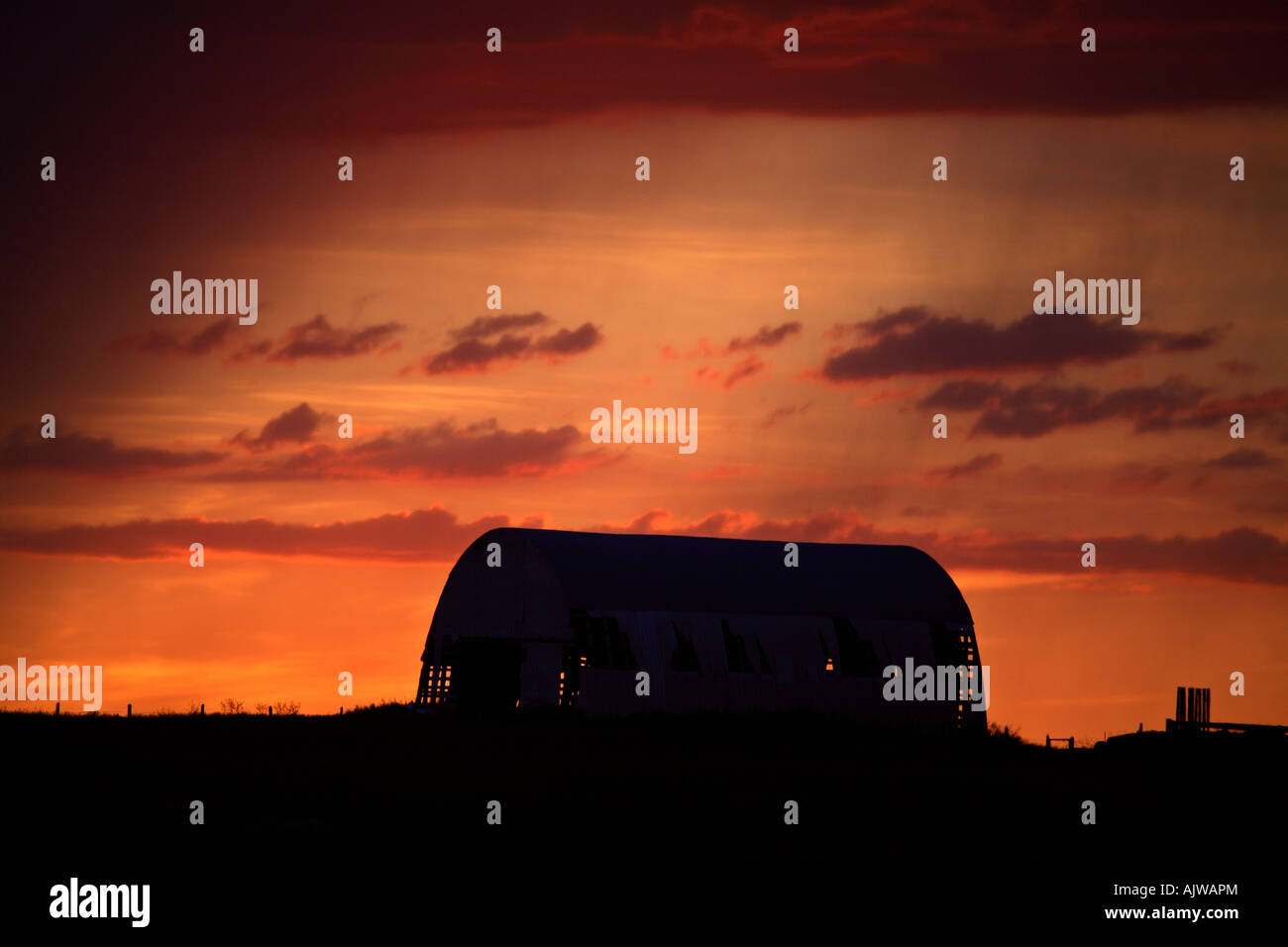 Sun setting behind an old barn Stock Photo - Alamy