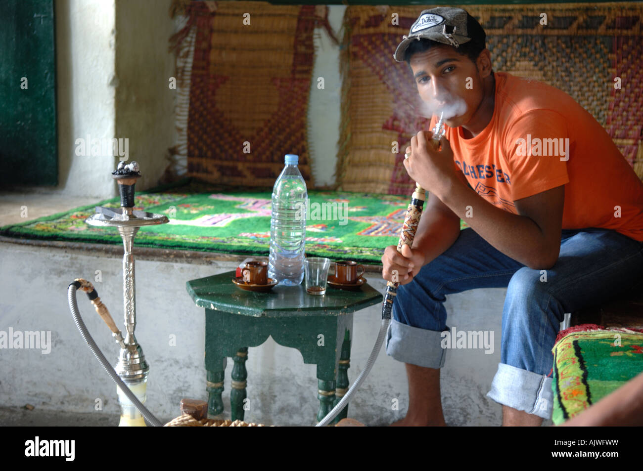 Inside a kairouan coffee house with a man smoking a chicha Stock Photo ...