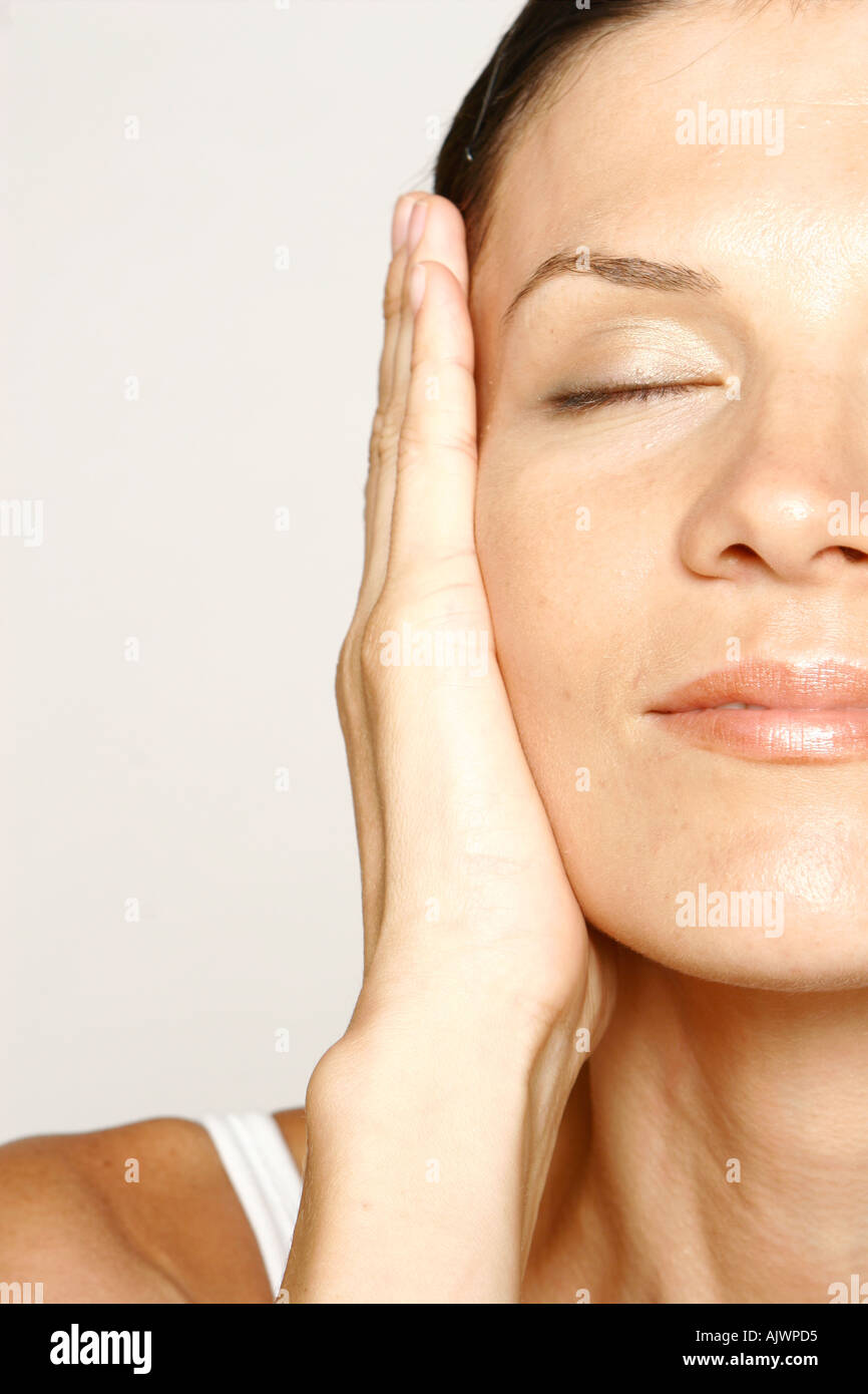 young woman with hand on face Stock Photo - Alamy