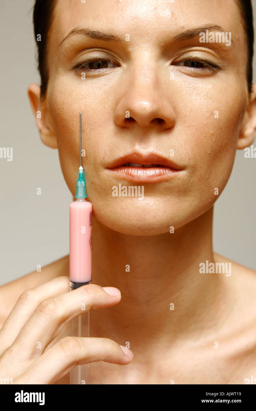 woman holding syringe by her face Stock Photo - Alamy