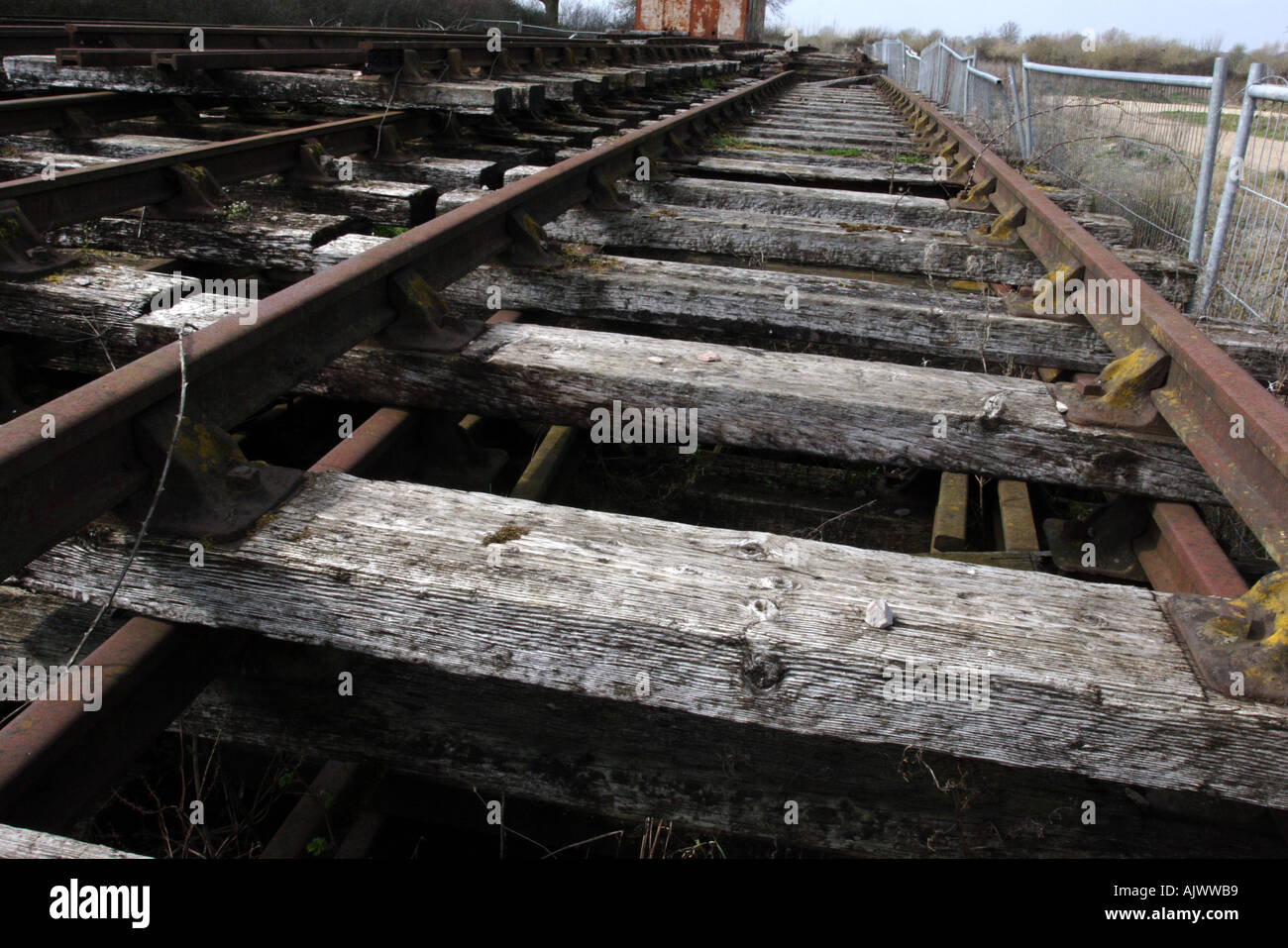 Stack of sections of railway track ready to be laid on prepared bed of ...