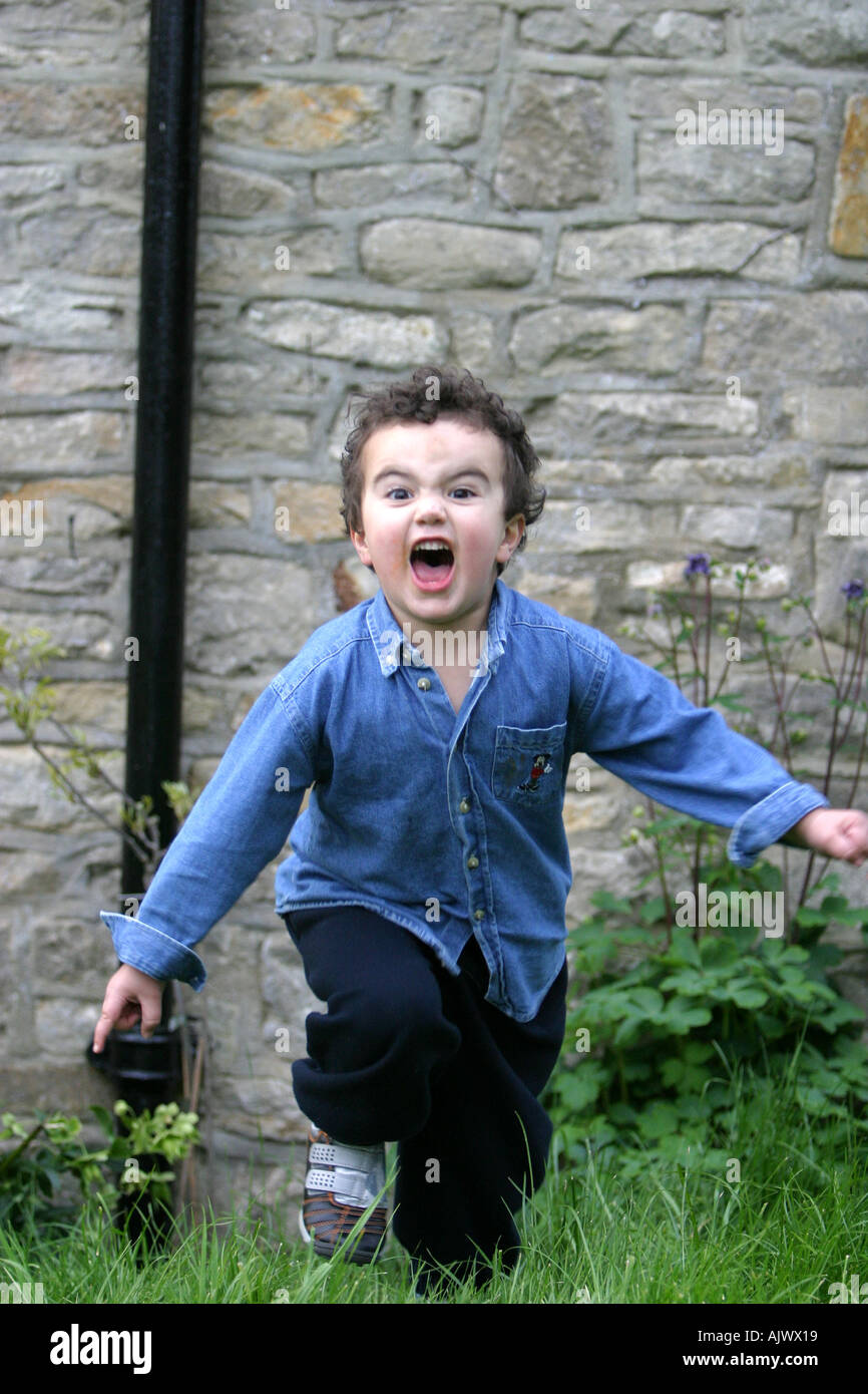Small boy running quickly towards the camera and shouting Stock Photo ...