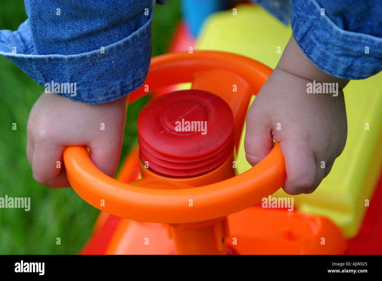 Child's hands on plastic toy steering wheel Stock Photo - Alamy