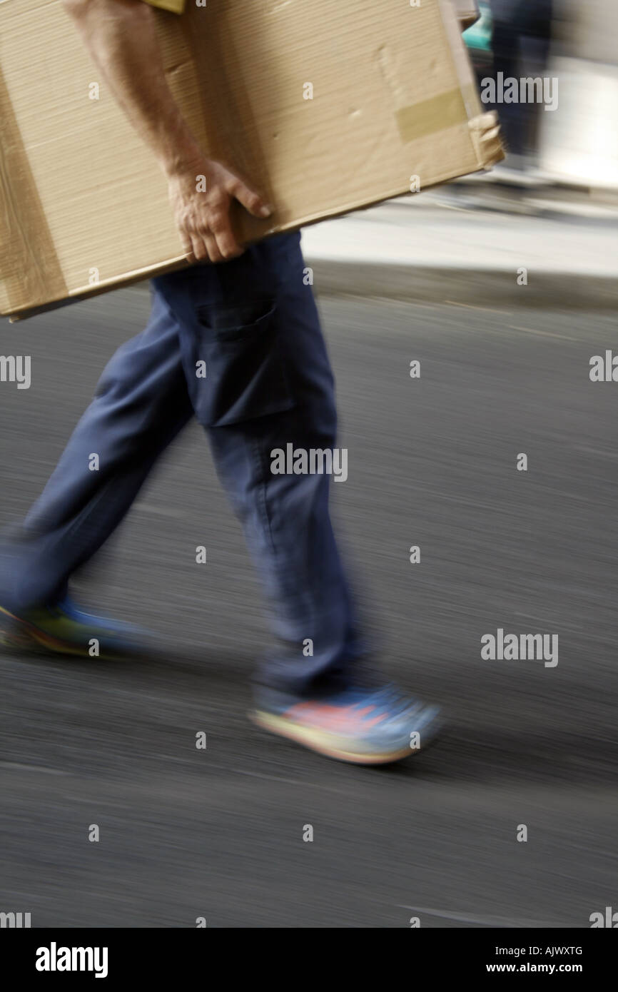 man carrying big parcel in town Stock Photo - Alamy