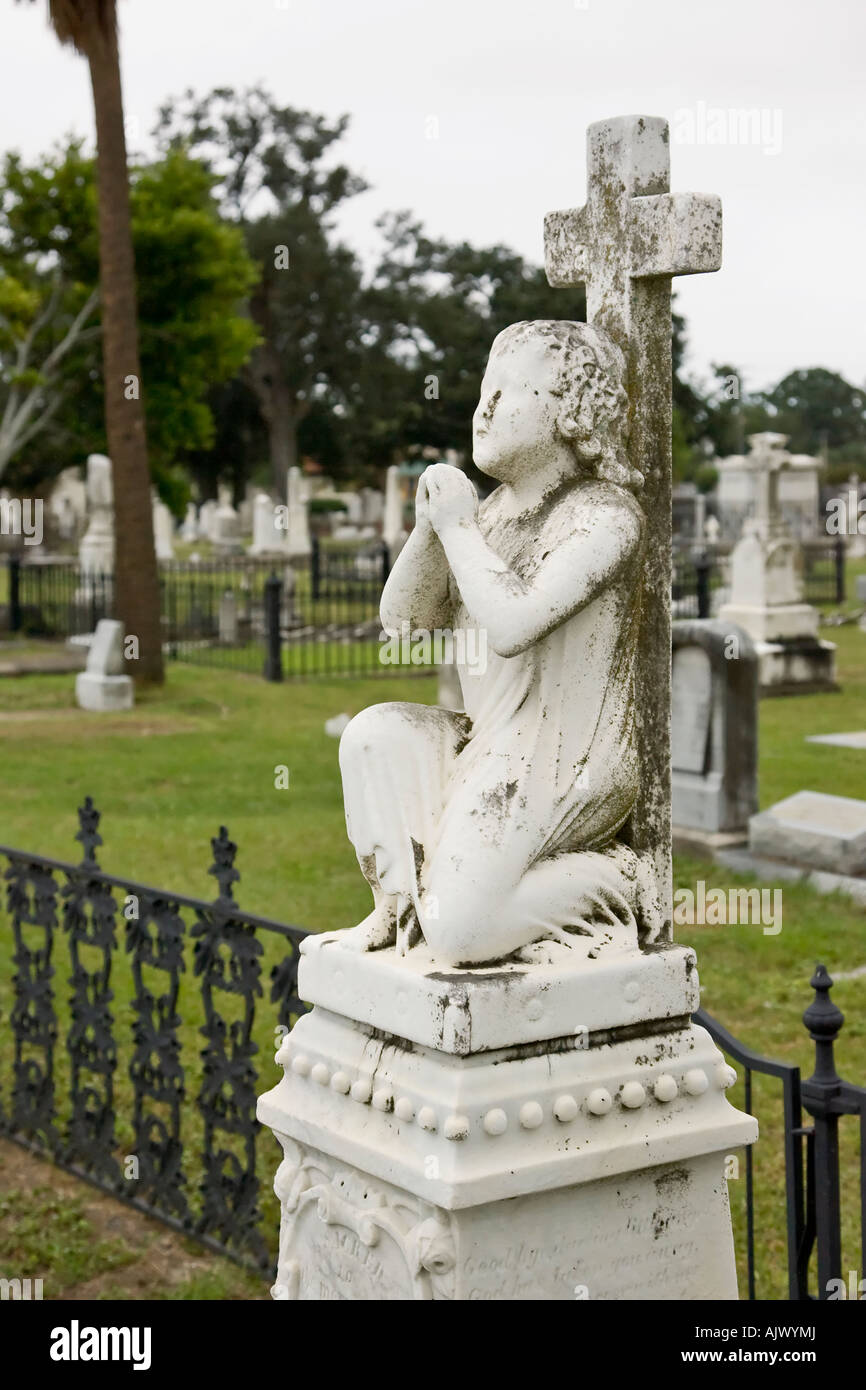Marble statue of child kneeling and praying in cemetery Stock Photo - Alamy
