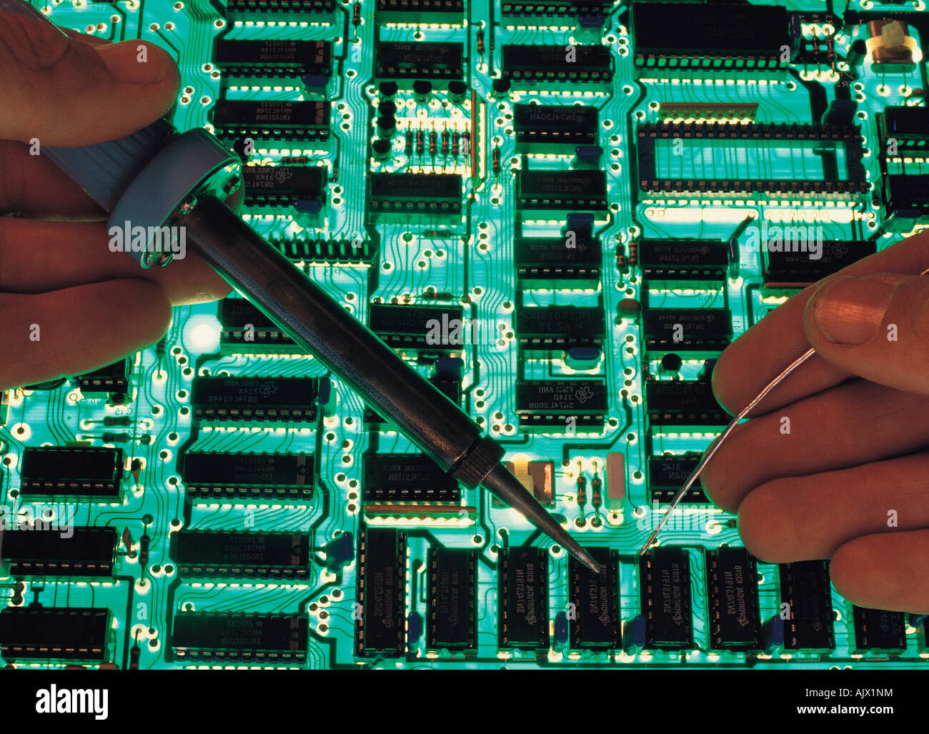 Microelectronics. Close-up of man's hands soldering electronic circuit ...