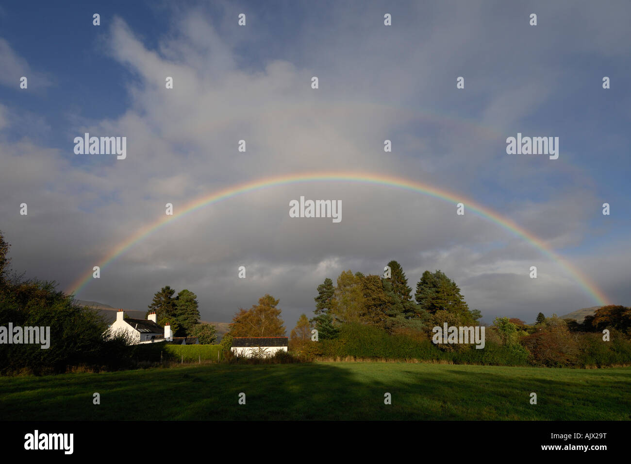 Dramatic sky with strong rainbow and faint double rainbow over the ...