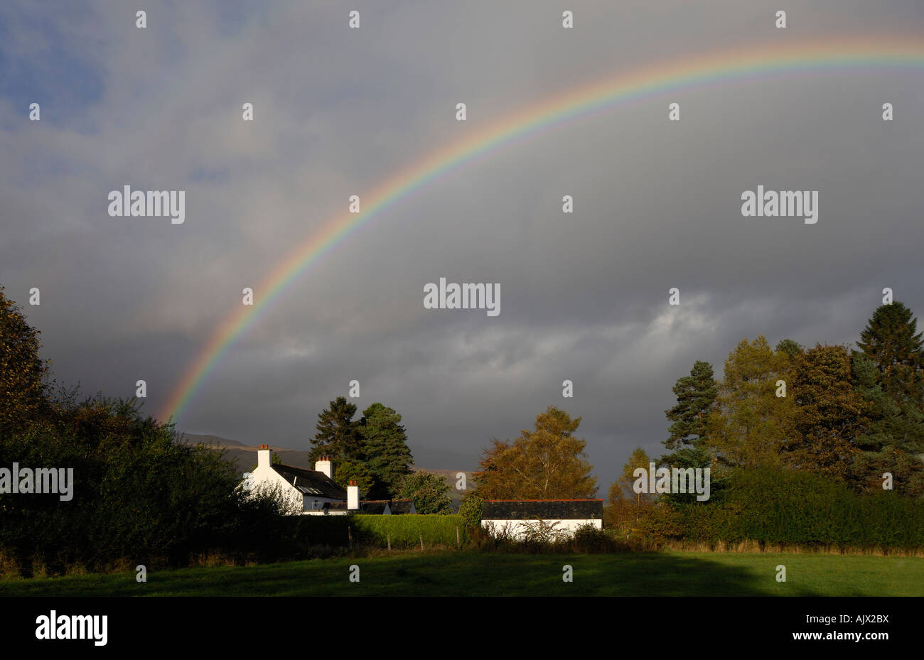 Dramatic sky with strong rainbow and faint double rainbow over the ...
