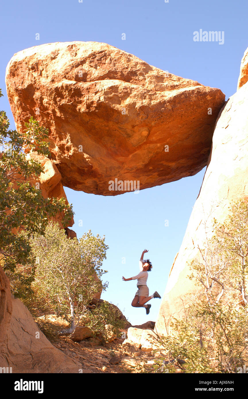 woman jumps under a big ol rock Stock Photo - Alamy