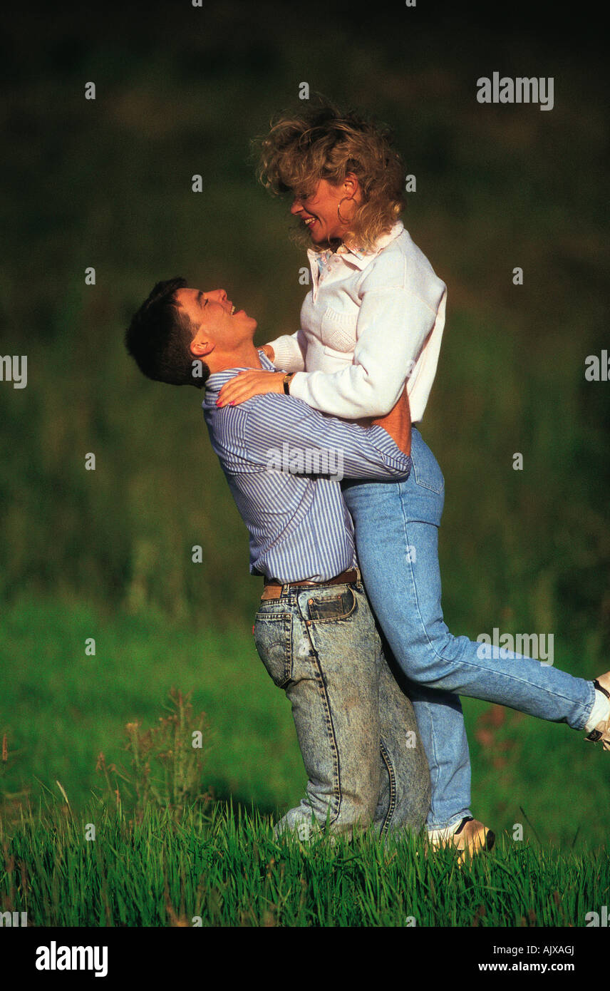 Young couple outdoors. Man lifting woman Stock Photo - Alamy